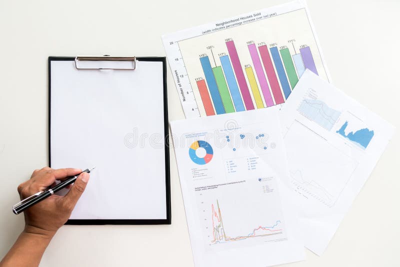Business Documents on Office Table with Graph Financial and Man Working ...