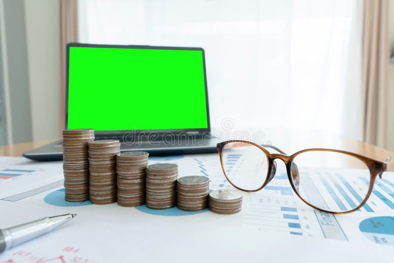 Business Documents on Table with Laptop Computer and Coin Stacks and ...