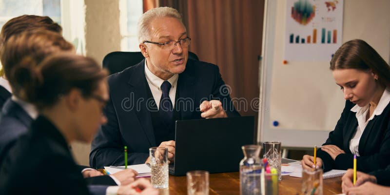 Business Elderly Leader Guides Team of Professionals through Strategy ...