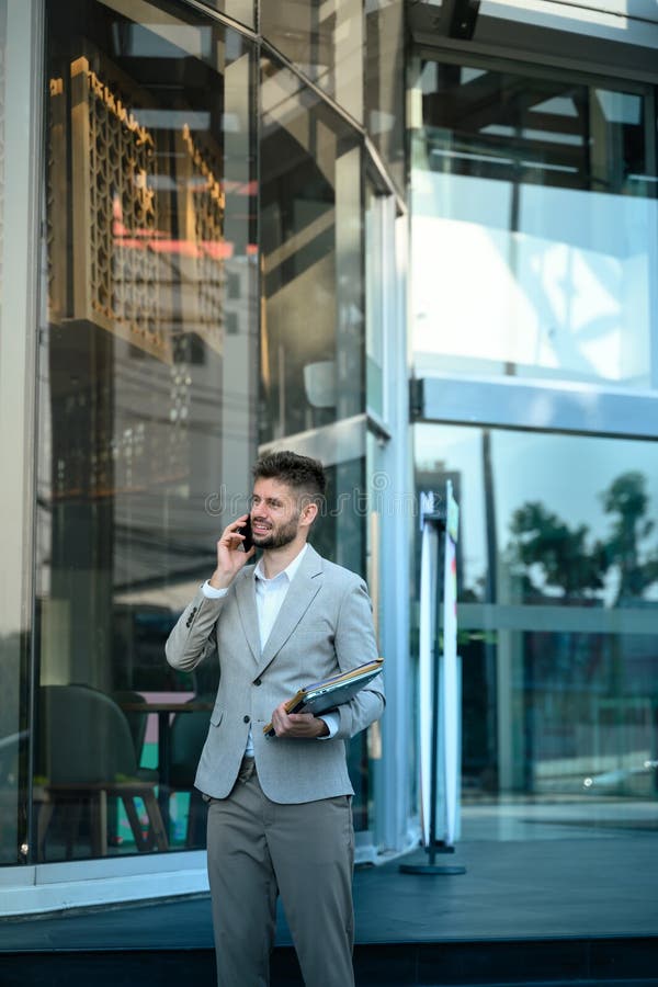 Business Executive Having Phone Conversation Outside Glass Office ...