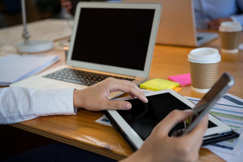 Business Executive Using Digital Tablet and Mobile Phone at Desk Stock ...