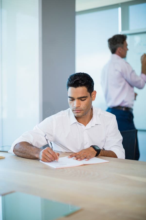 Business Executive Writing on Notebook in Conference Room Stock Image ...