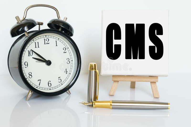 On the Table There is a Clock, a Pen and a Stand with a Card on Which ...