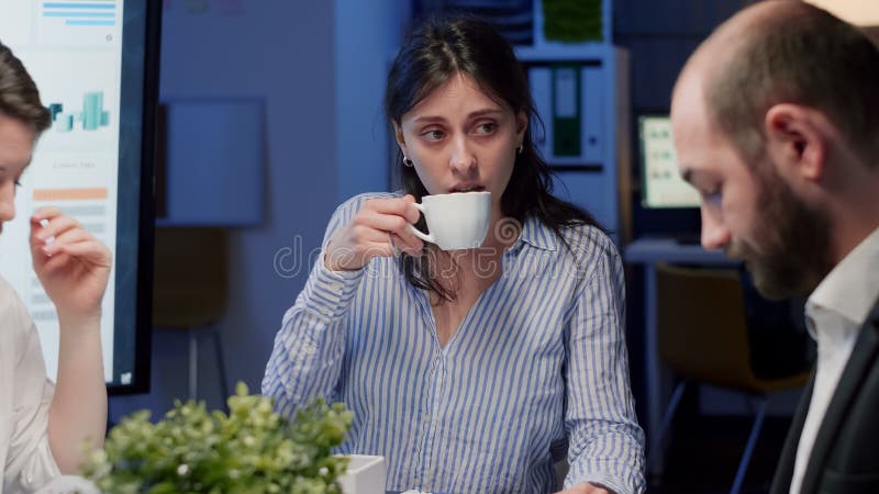 Business Leder Holding Cup of Coffee while Discussing with Multi Ethnic ...