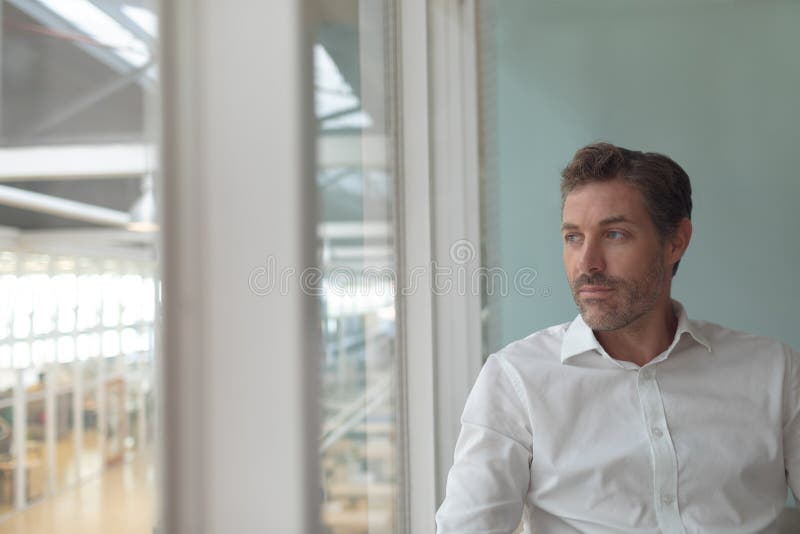 Business Male Executive Looking through Window in a Modern Office Stock ...