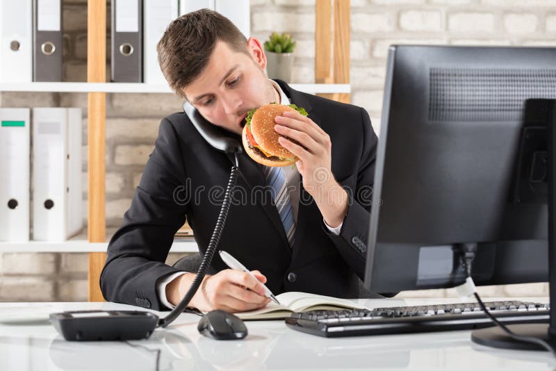Business Man at Desk Eating Burger and Working Stock Photo - Image of ...