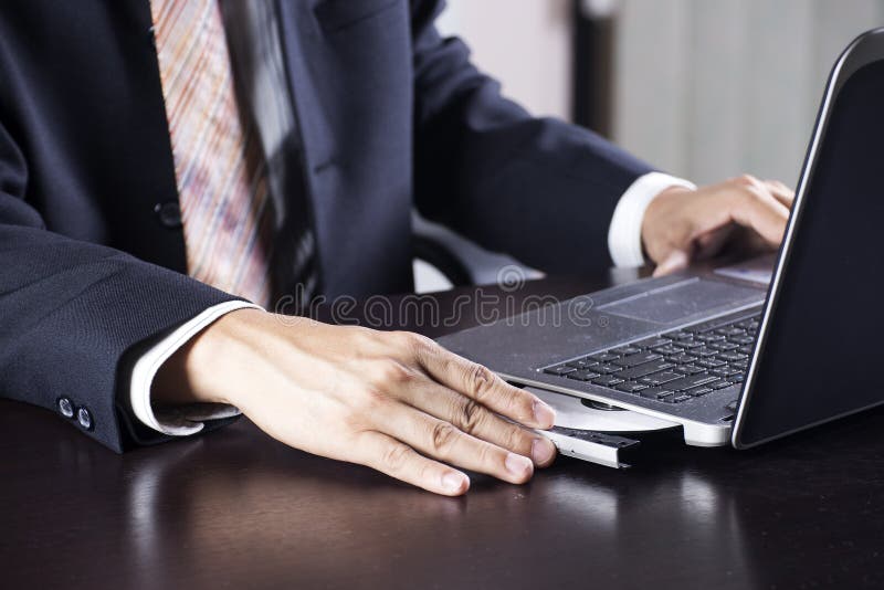 Business Man Holding Disk Insert To Laptop Stock Photo - Image of eject ...