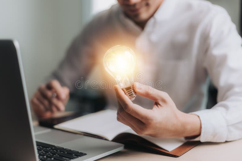 Business Man Holding Light Bulbs and Using Laptop, New Ideas with ...