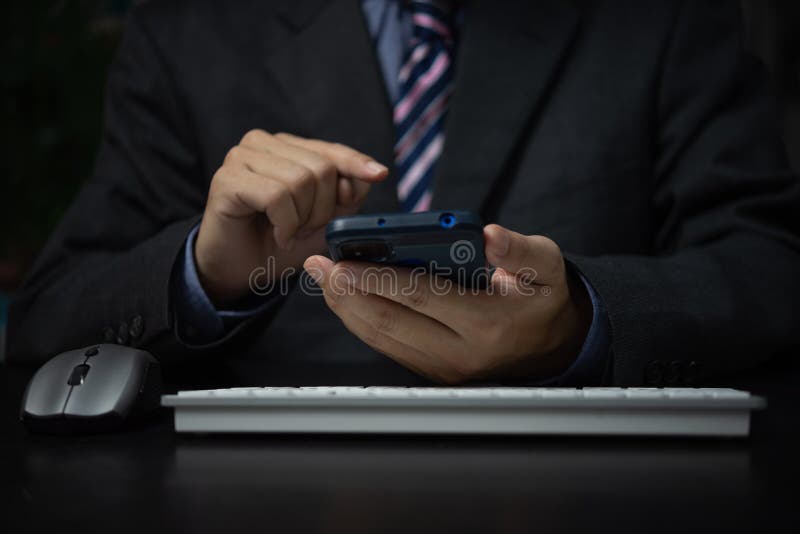 Business Man Holding Mobile Smartphone and Keyboard Computer on Desk ...