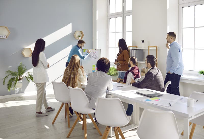 Business Man Makes Presentation and Explains Strategy on Board in Front ...