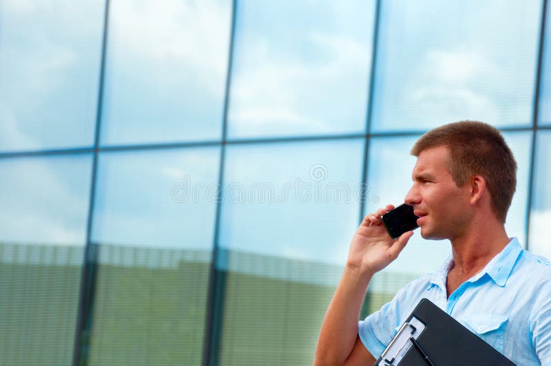 Business Man with Notebook and Mobile Phone in Front of Modern Business ...