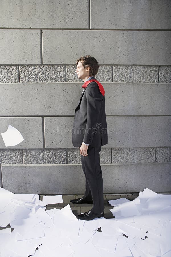 Business Man Surrounded by Paper Material beside Wall Stock Image ...