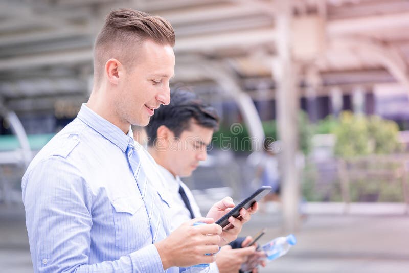 Business Man Taking a Break Drinking Water and Using Mobile Phone Stock ...
