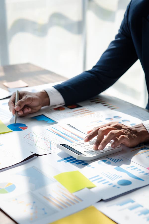Business Man Using a Calculator To Calculate Numbers on a Company Stock ...