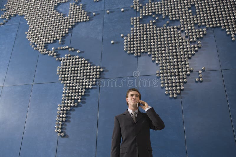 Business Man Using Mobile Phone in Front of World Map in Office Stock ...