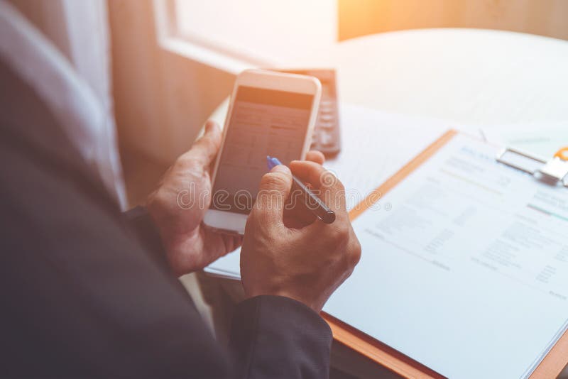 Business Man Using Smart Phone Working with Documents on His Desk Stock ...