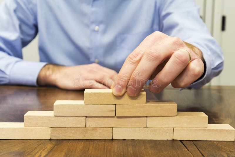 Business Man and Wall Built with Small Wooden Blocks Stock Photo ...