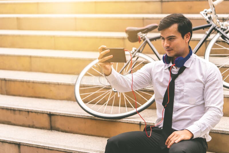 Business Man Watching Video on Mobile with His Bicycle on the Si Stock ...