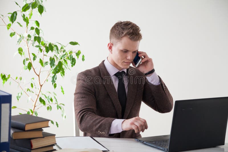 Business Man Working at the Computer and Talking on the Phone in the ...