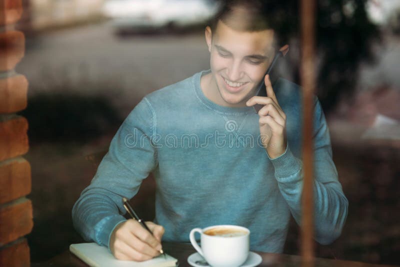 Business Man Working and Drinking Coffee in a Cafe and Write Down ...