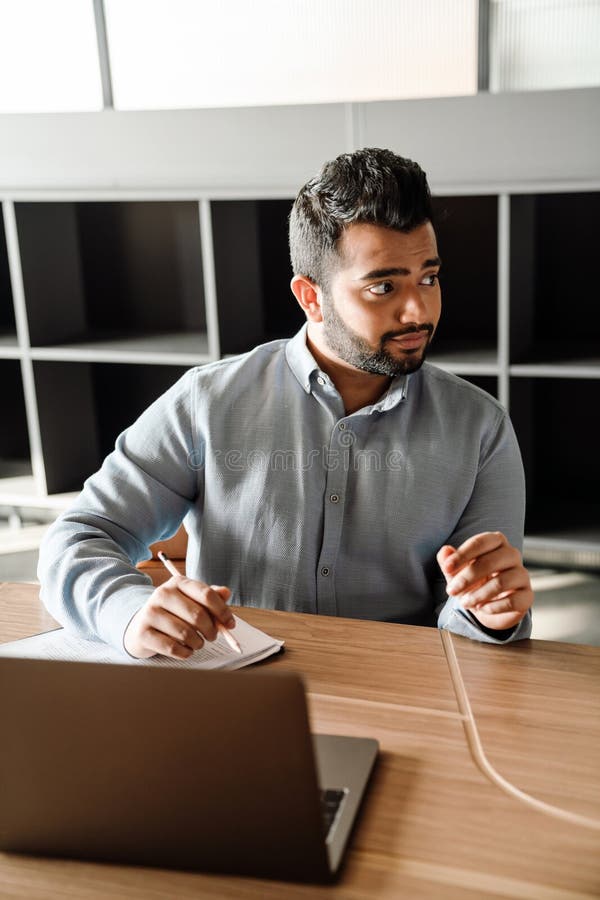Business Man Writing Down Notes while Working on Laptop in Office Stock ...