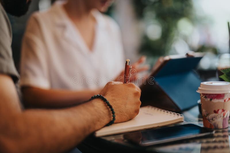 Business Meeting in Coffee Shop with People Taking Notes and Using ...