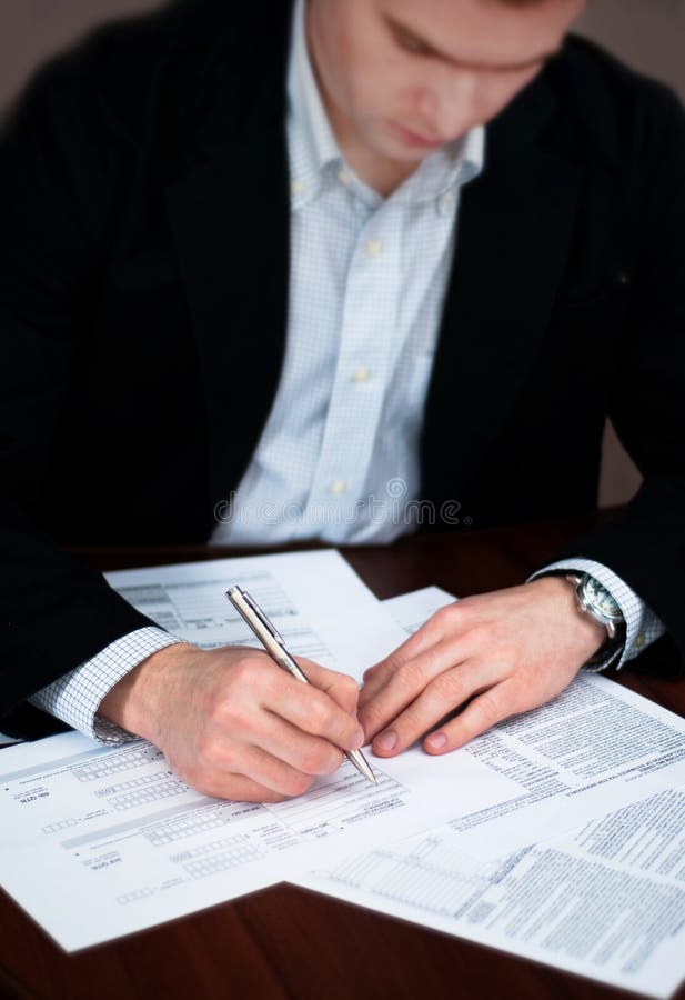 Business Men Filling Out Documents on a Desk. Stock Image - Image of ...