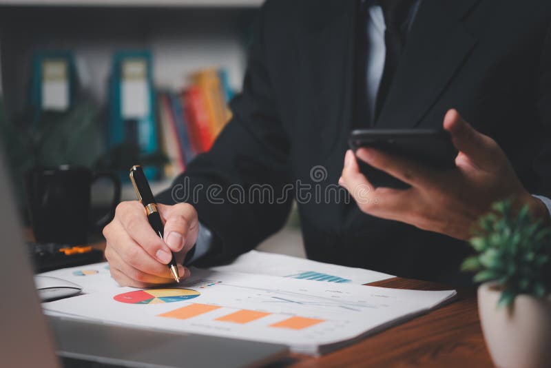 Business Men Hand Holding Mobile Phones and Pens on the Desk. Business ...