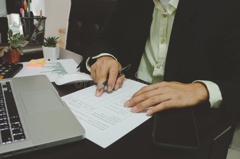Business Men Look at Business Documents and Hold Pens with Computer ...