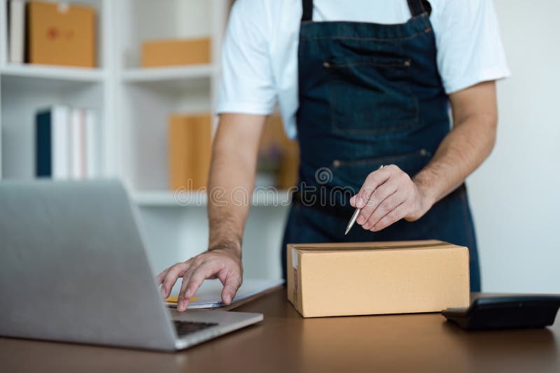E-commerce Business Owner Preparing Package for Shipping with Laptop ...