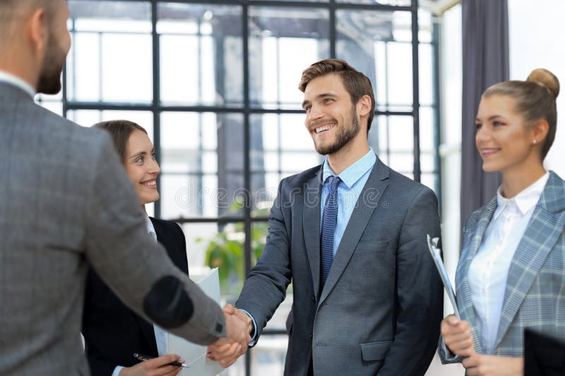 Business Partners Handshaking Over Business Objects on Workplace. Stock ...