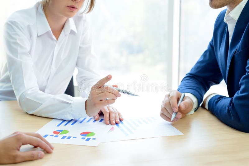 Business People Analyzing Financial Results on Graphs Around the Table ...