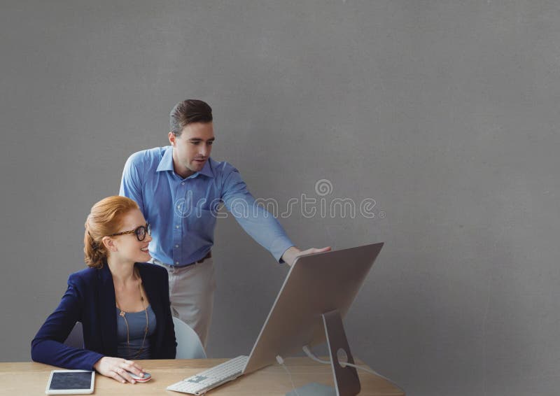 Business People at a Desk Looking at a Computer Against Grey Background ...