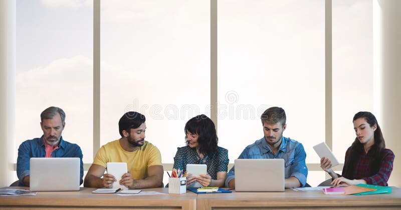 Business People at a Desk Looking at Computers and Tablets Stock Photo ...