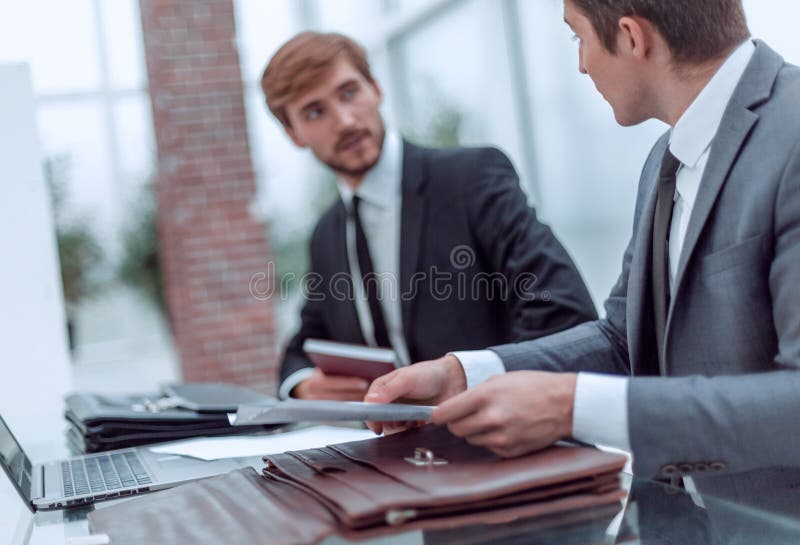Business People Discussing Documents Sitting at the Office Desk. Stock ...