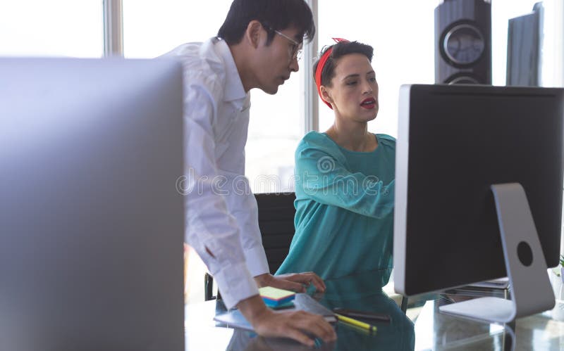 Business People Discussing Over Computer at Desk in Office Stock Photo ...