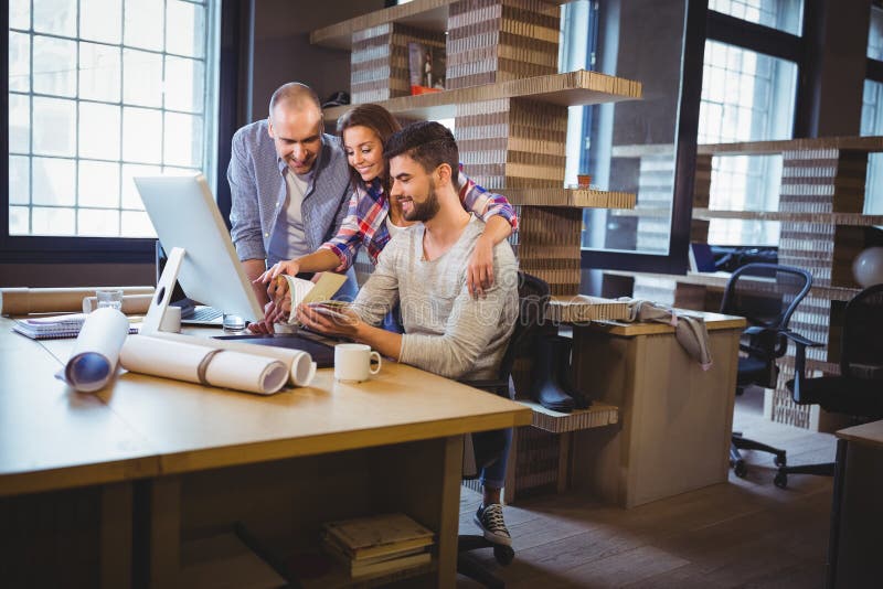 Business People Discussing Over Document at Computer Desk Stock Photo ...