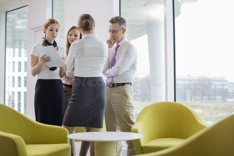 Business People Discussing Over Documents in Lobby Stock Image - Image ...