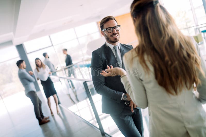 Business People Discussing Over Documents in Office Lobby. Stock Photo ...