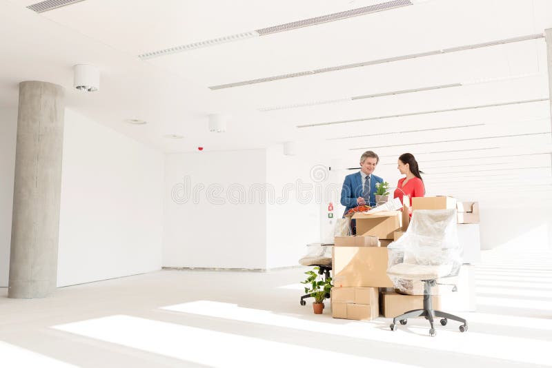 Business People Discussing while Standing by Cardboard Boxes in New ...