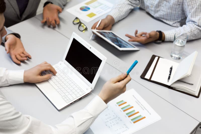 Business People Discussion at Table Using Variety of Electronic Devices ...