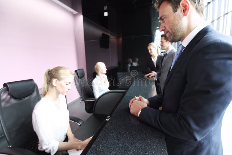 Business People at Front Desk Stock Photo - Image of indoors, desk ...