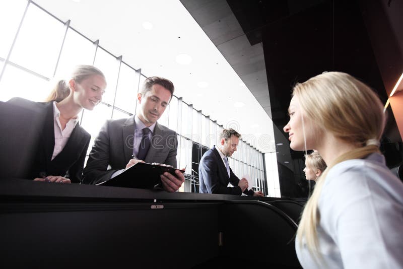 Business People at Front Desk Stock Image - Image of lobby, standing ...