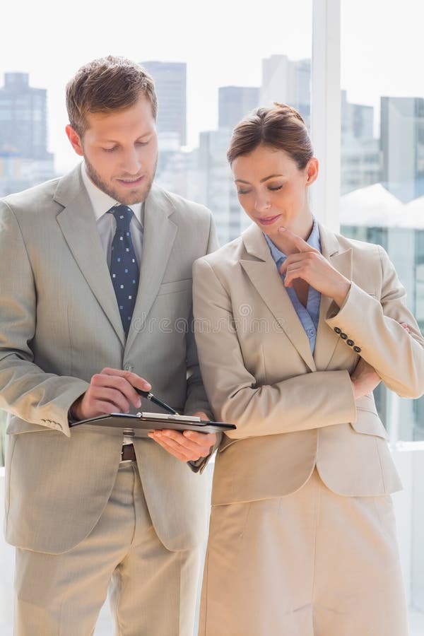 Business People Going Over Document on Clipboard Stock Image - Image of ...