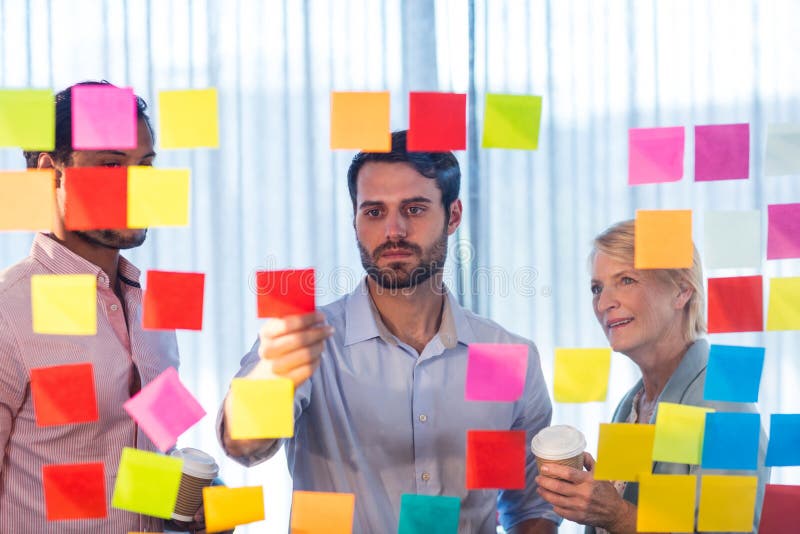 Business People Looking at Post it on the Wall Stock Image - Image of ...