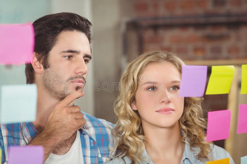 Business People Looking at Sticky Notes Attached on Glass Stock Photo ...