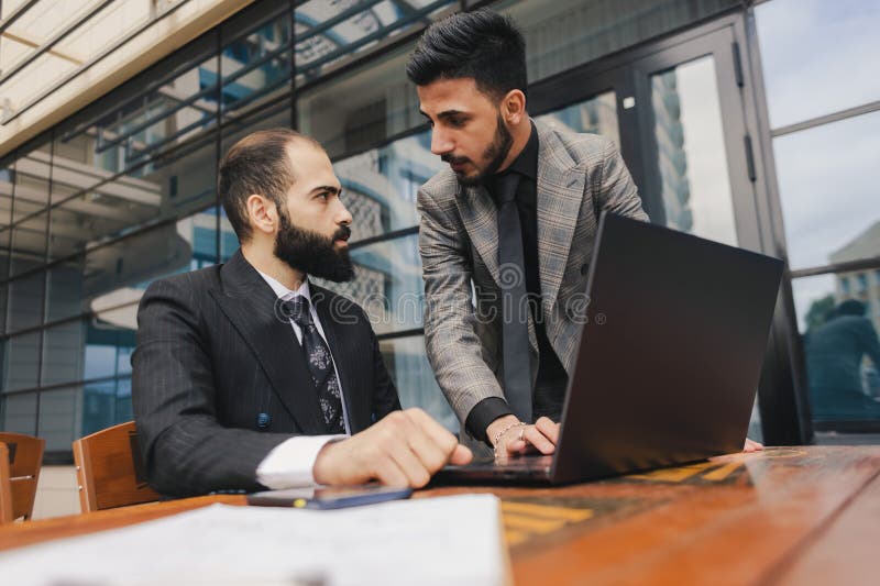 Business People Meets Outdoors. Two Men are Using a Laptop. Working ...