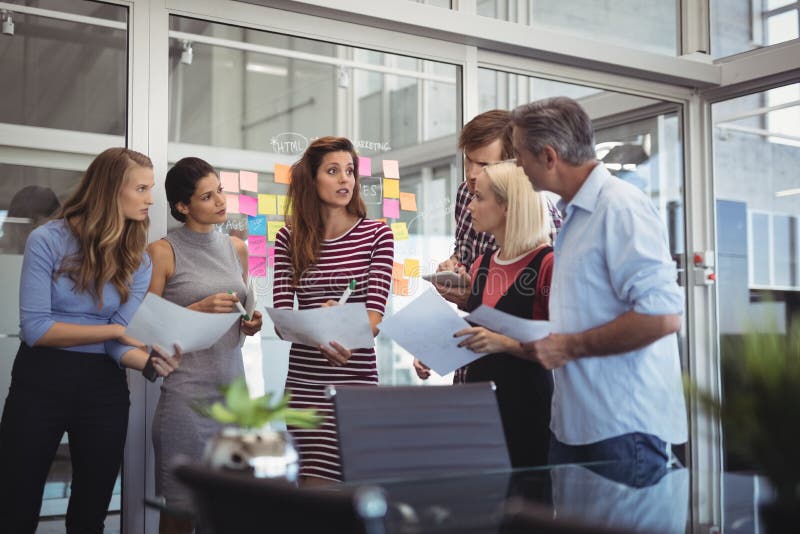 Business People with Papers Having Discussion in Creative Office Stock ...