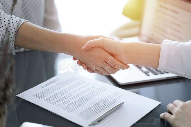 Business People Shaking Hands Above Contract Papers in Office Stock ...