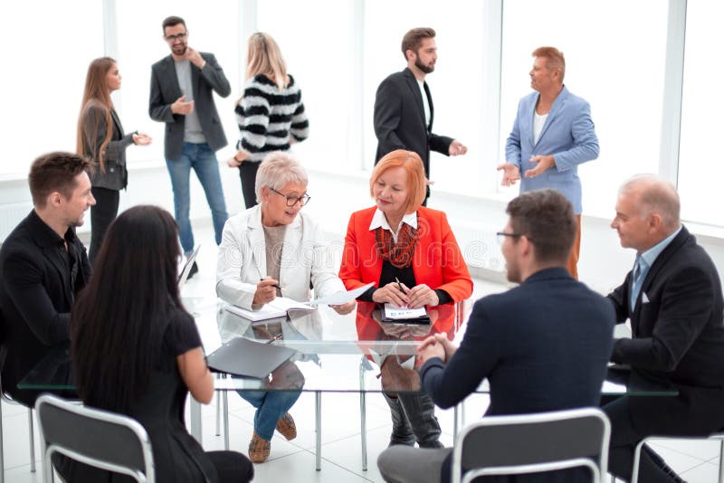 Business People Sitting Around the Desk in a Meeting and Making Stock ...
